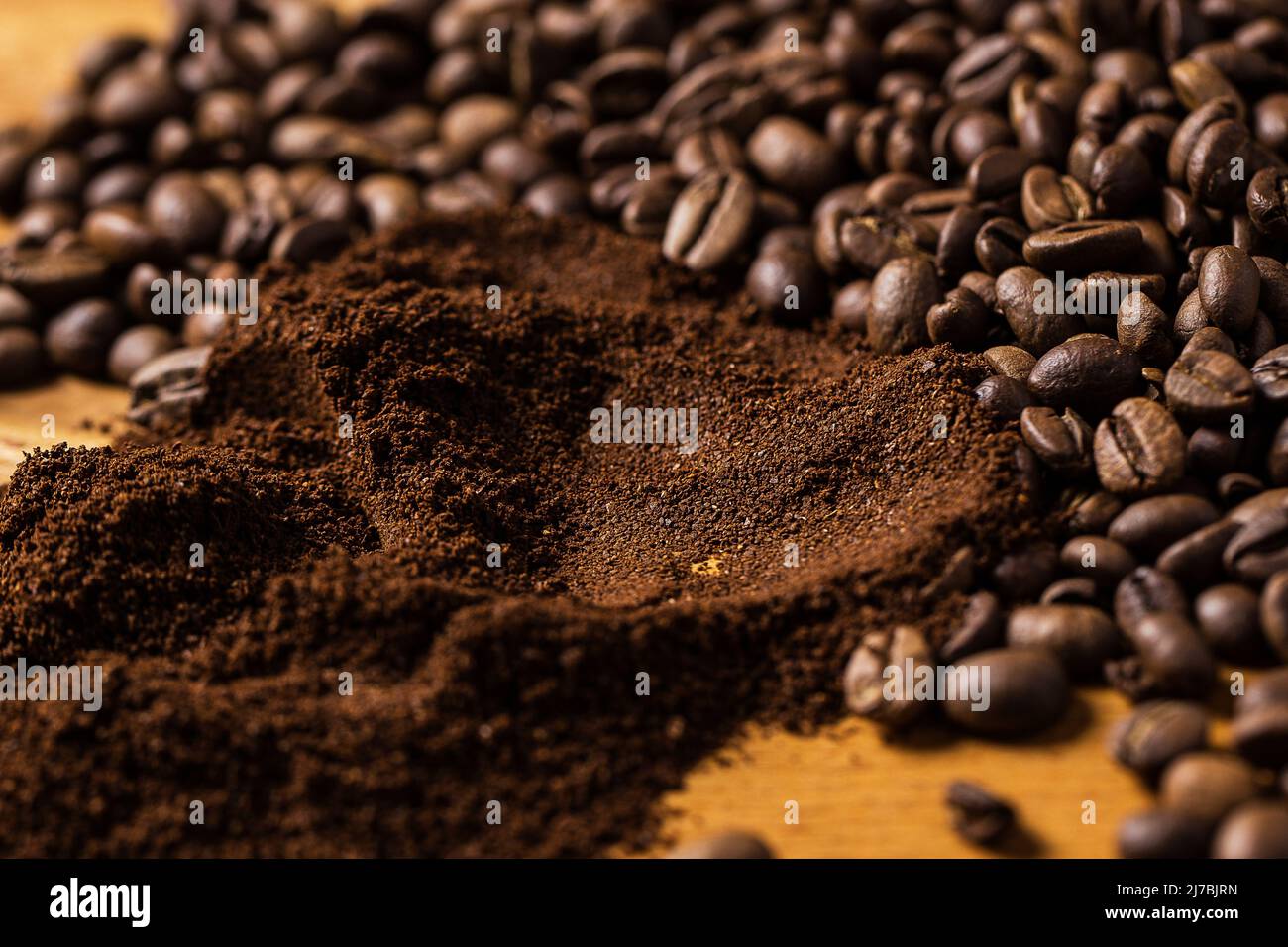 Coffee beans and grounded coffee over wooden surface Stock Photo - Alamy