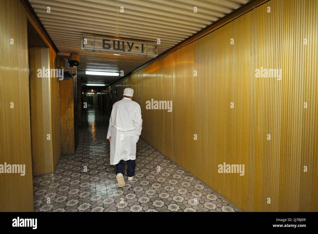 Worker in protective cloth going down the passageway of the Chernobyl ...