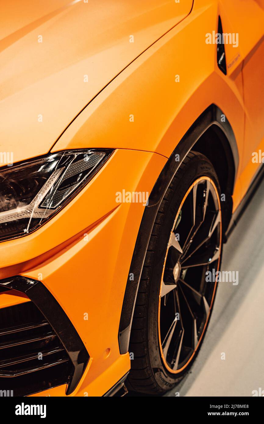 Detail of the front wheel of an orange sports car where you can see ...