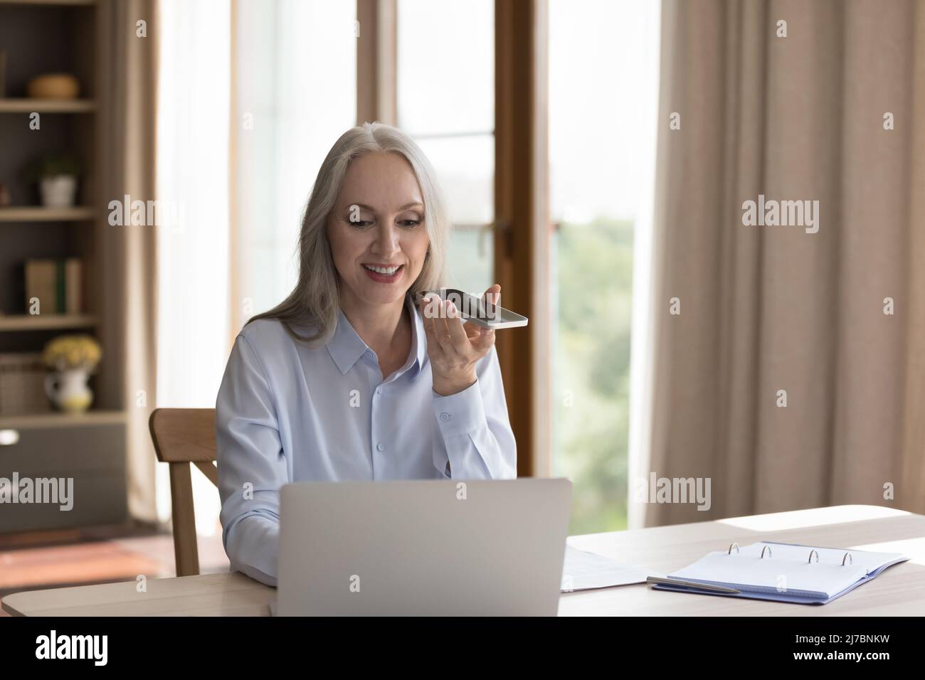 Happy grey haired freelance business lady using virtual assistant Stock ...