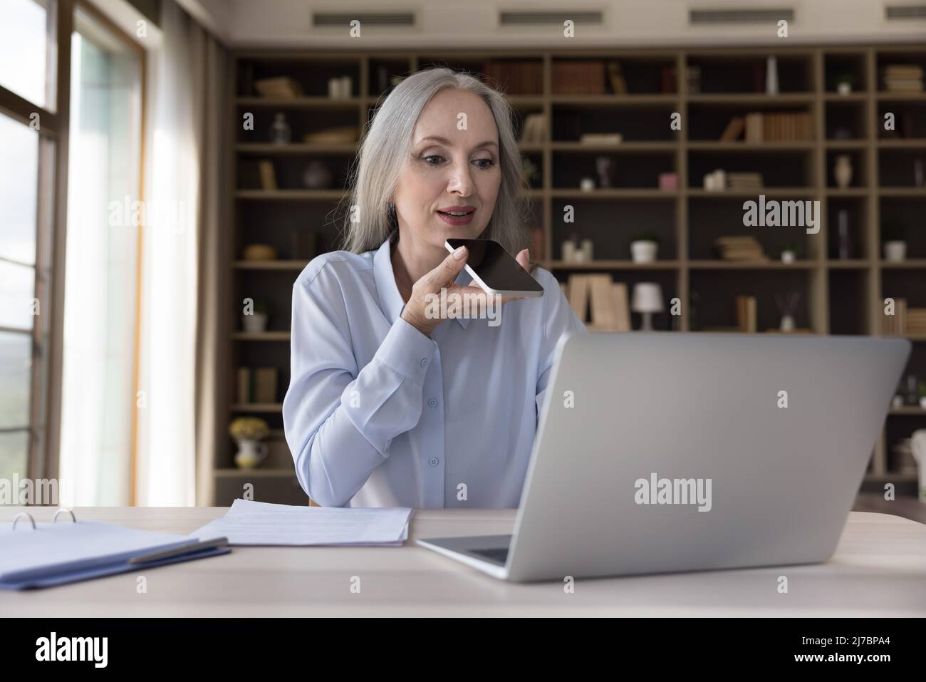 Engaged mature business woman making phone call Stock Photo - Alamy