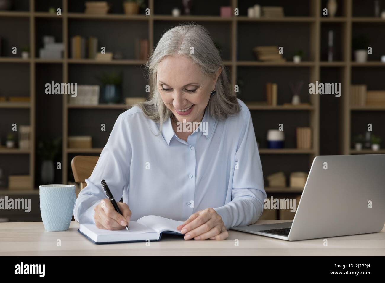 Happy busy senior freelance employee woman writing notes Stock Photo ...