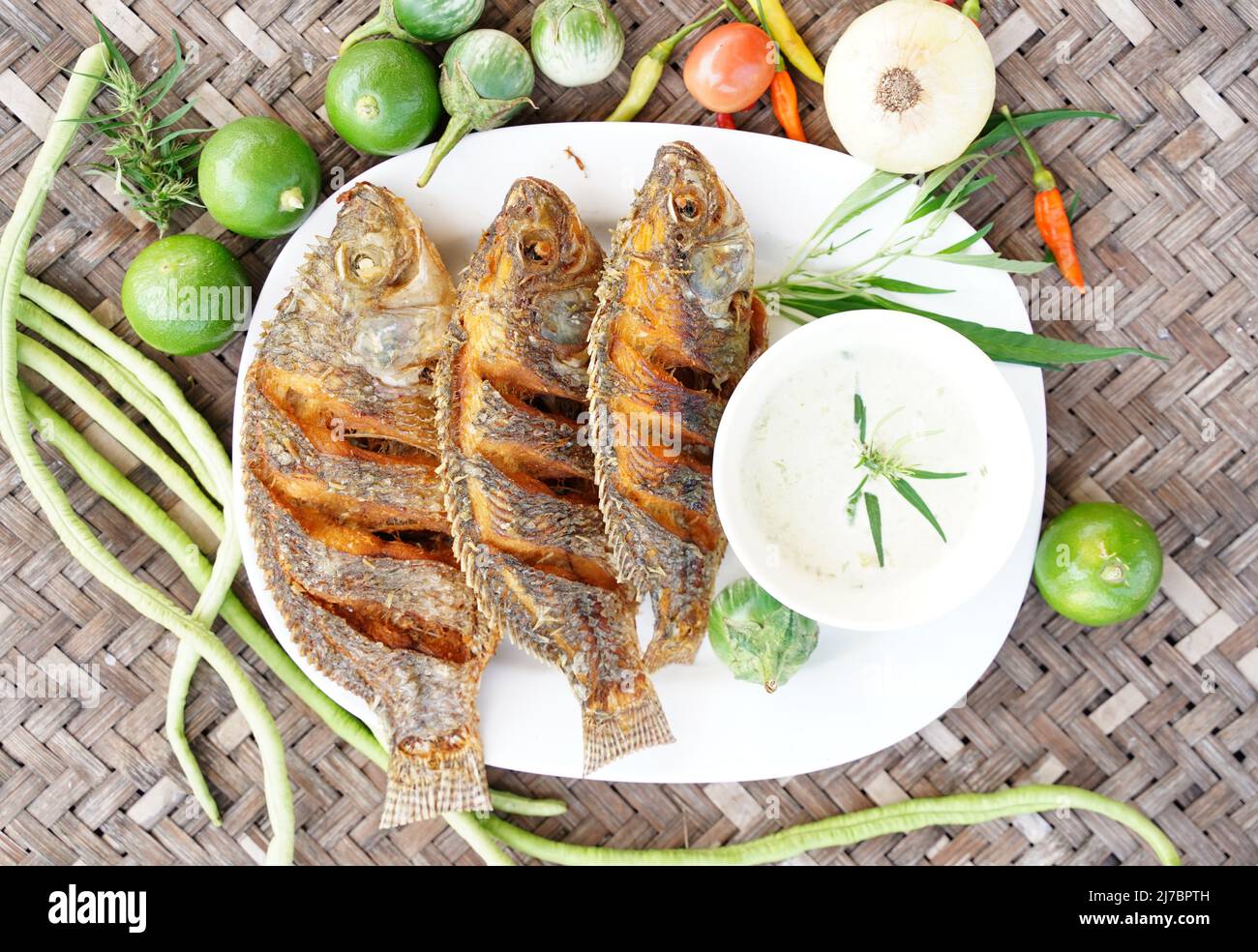 Top View Crispy fish with local platter with various vegetables as a ...