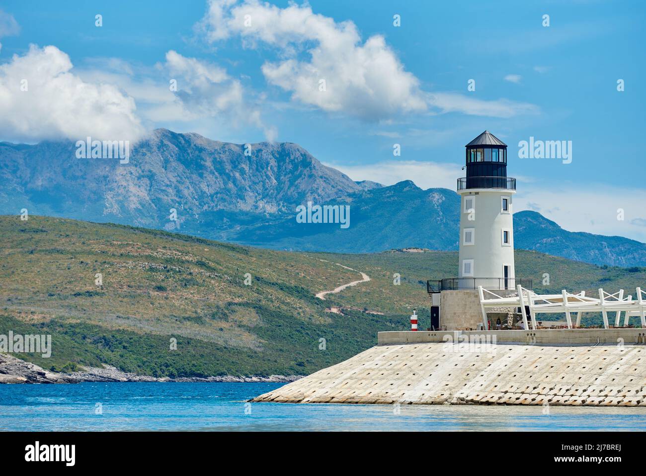 Landscape with lighthouse by the sea against mountain in Lustica Bay ...
