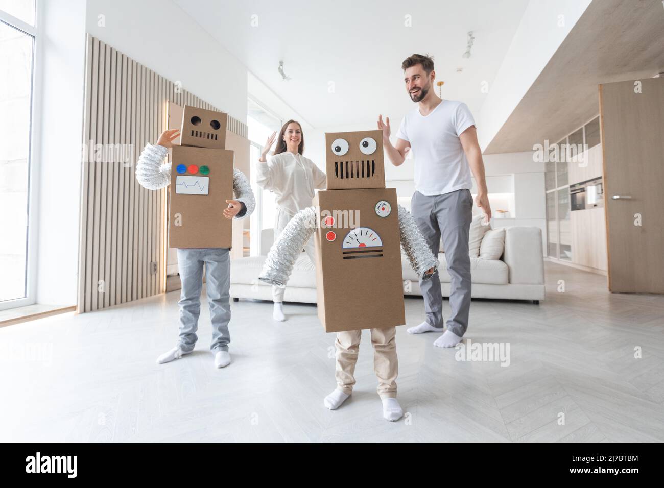 Happy family of parents and two children playing dancing like robots at ...