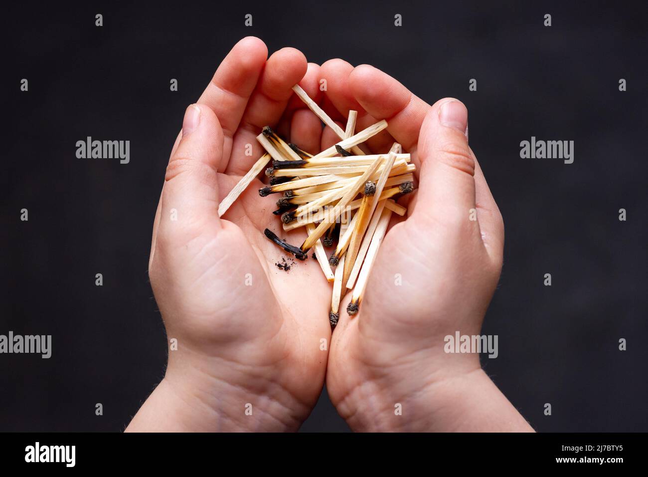Burnt matches in children's hands. Charred matches Stock Photo - Alamy