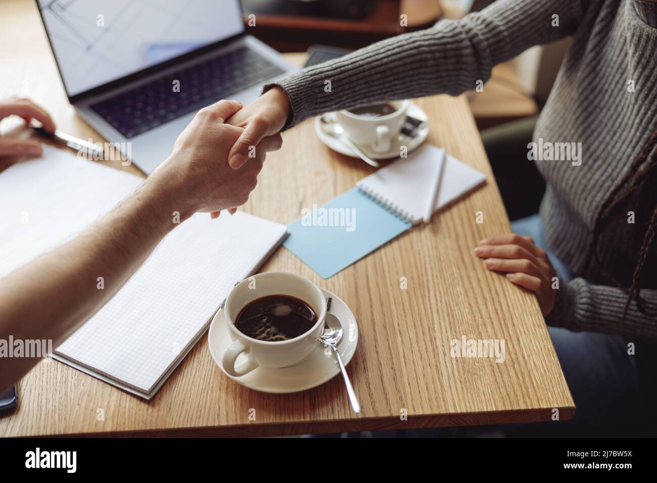 Hands shake gesture. Business agreement at coffee break. Top view. Man ...