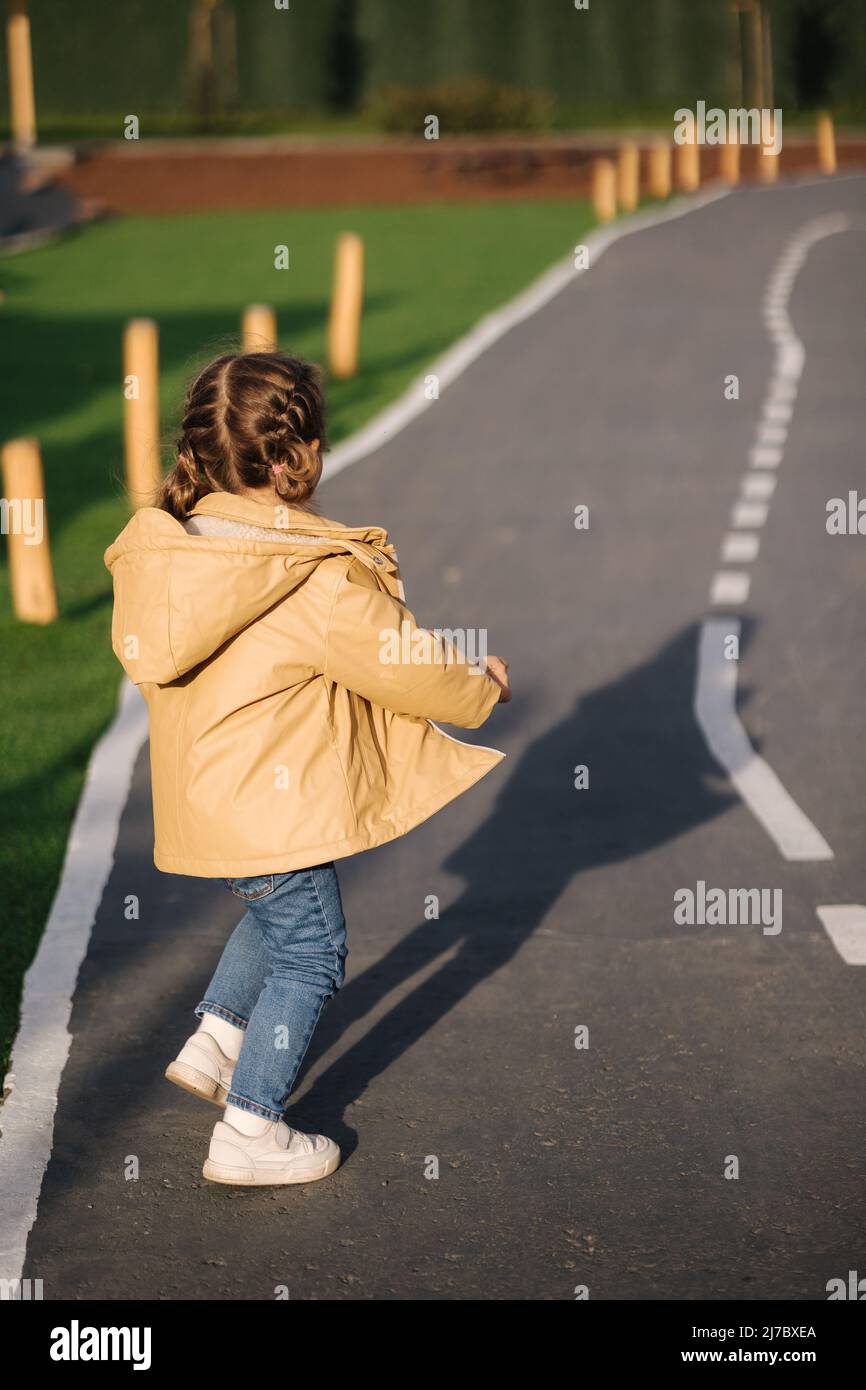 Back view of little girl walking in little kids city. Toy city for ...