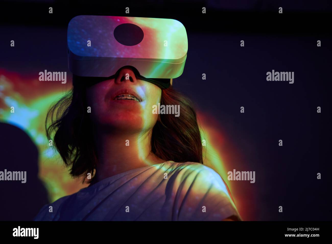 Woman is using virtual reality headset. Elements of this image ...