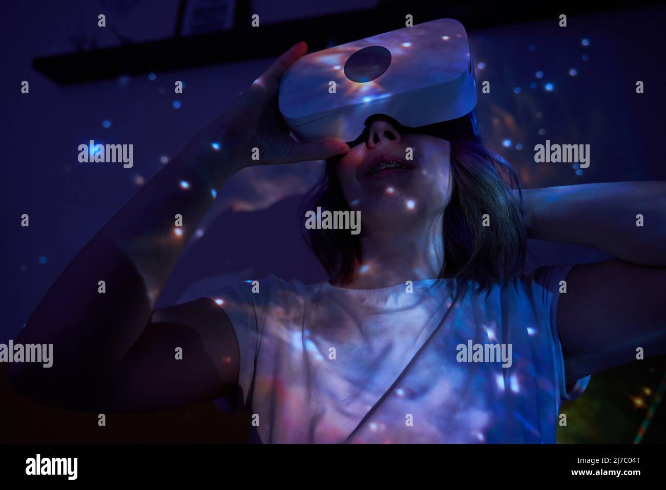 Woman is using virtual reality headset. Elements of this image ...
