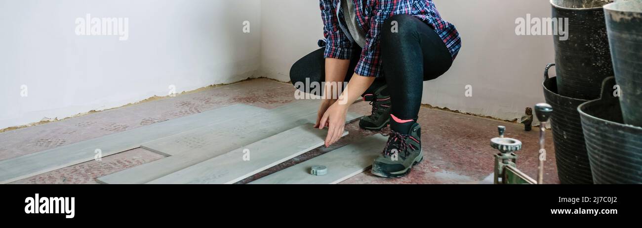 Female bricklayer placing tiles to install a floor Stock Photo - Alamy