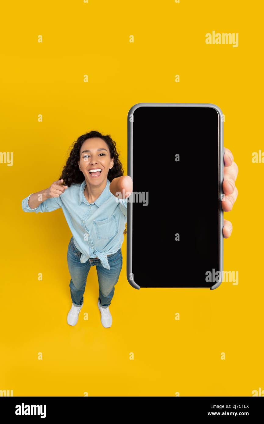 Happy lady showing blank mobile phone screen at studio Stock Photo - Alamy