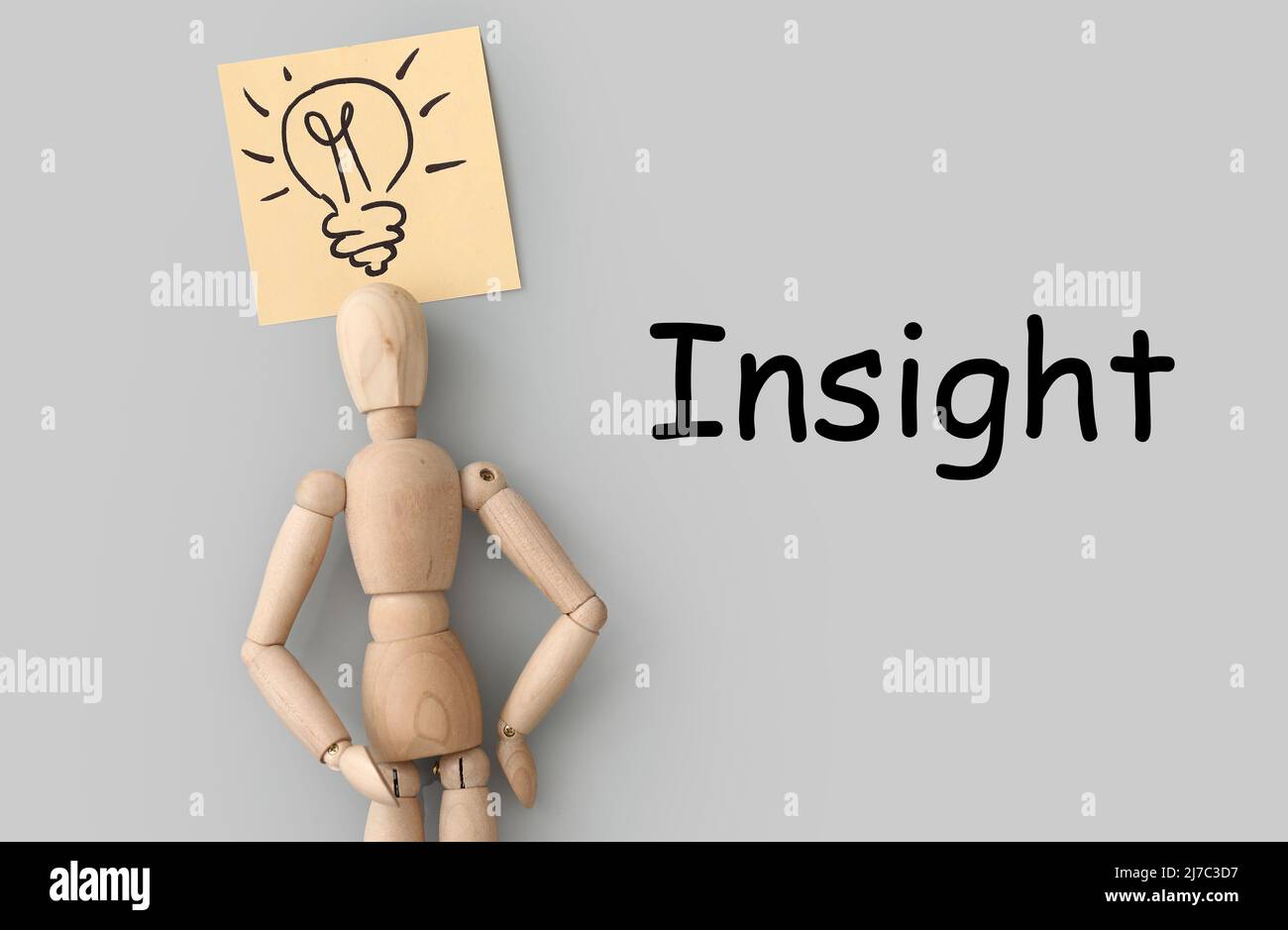 Wooden mannequin with drawn light bulb and INSIGHT on grey background ...