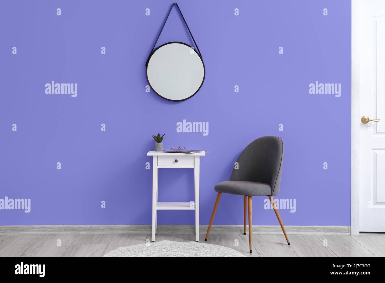 Modern chair and table near wall with mirror Stock Photo - Alamy