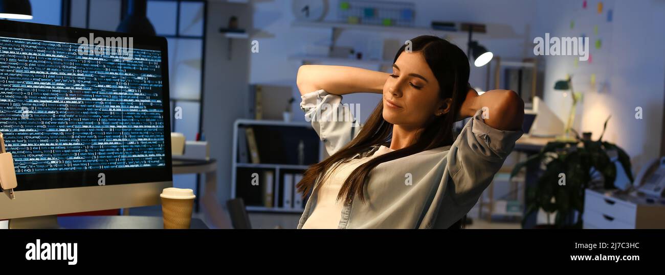 Female programmer relaxing in office at night Stock Photo - Alamy