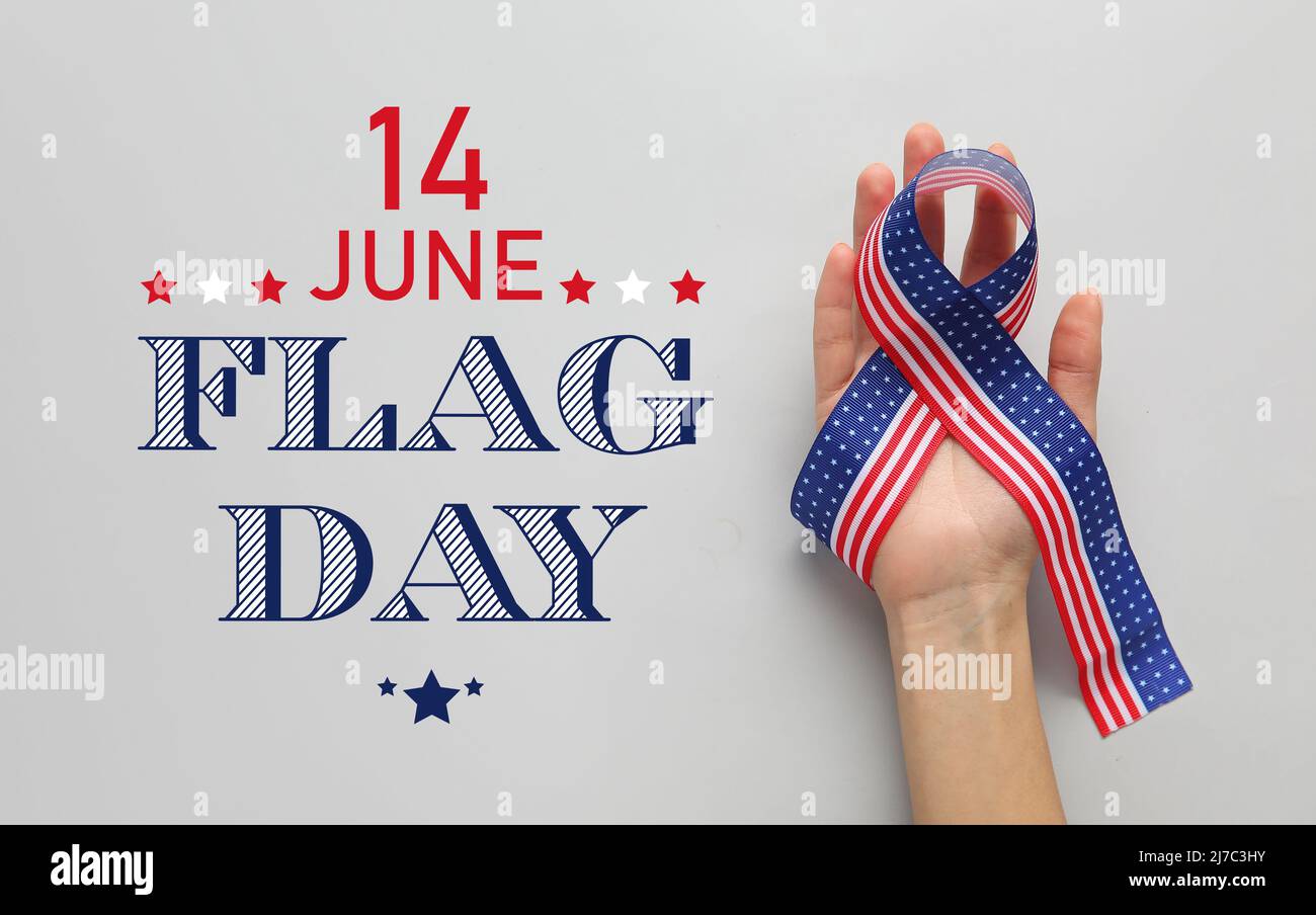 Hand holding ribbon in colors of American flag and text 14 JUNE, FLAG ...