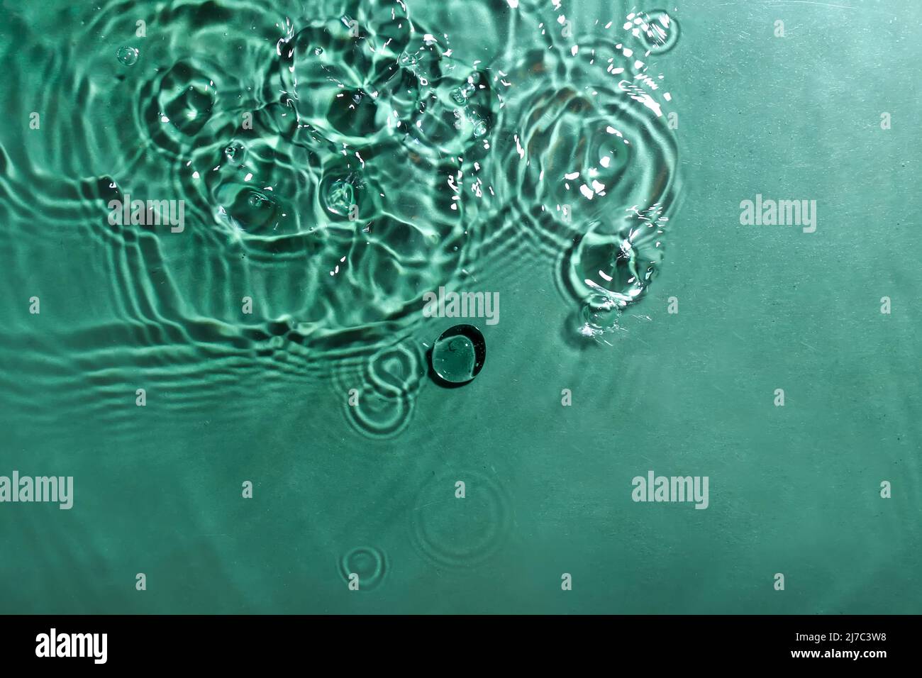 Clean water with splashes on color background Stock Photo - Alamy