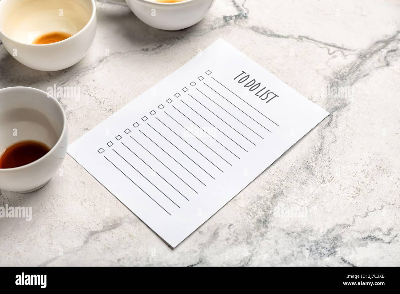 Blank to do list and dirty empty cups on light table Stock Photo - Alamy