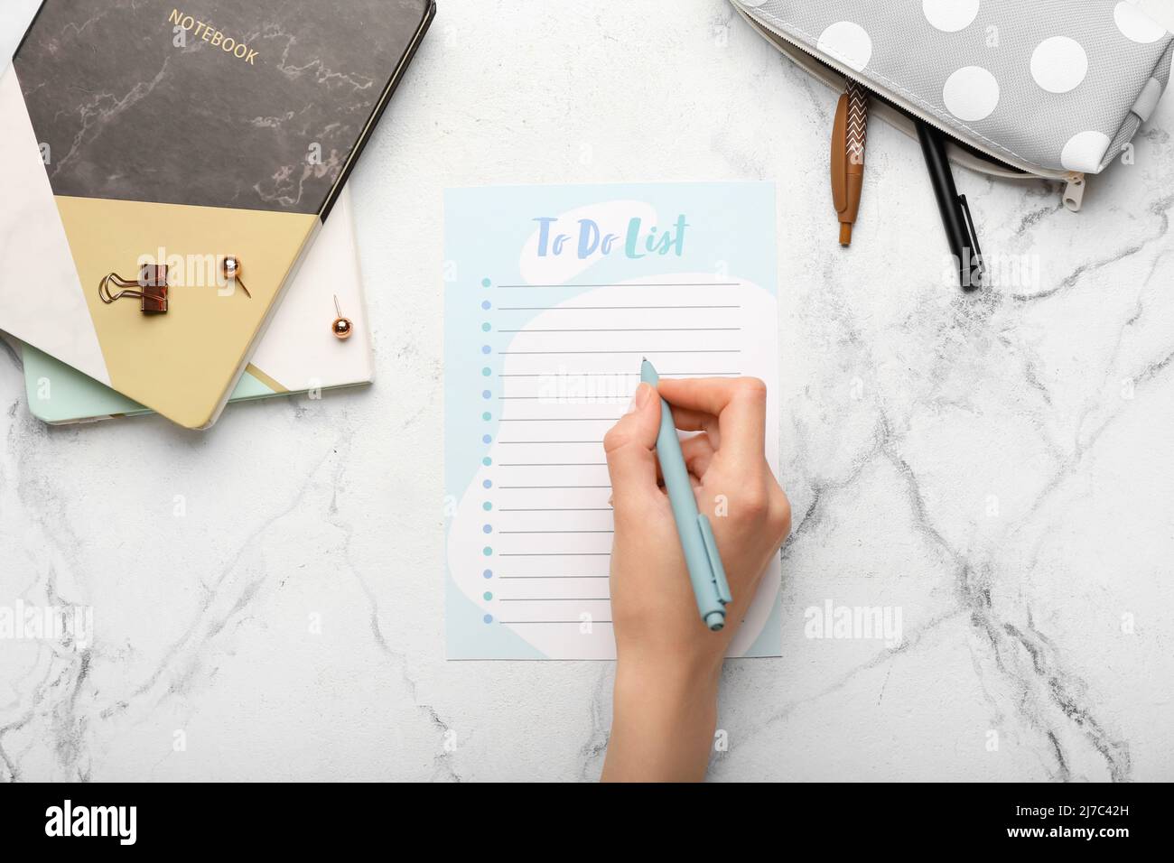 Female hand with to-do list and stationery on light background Stock ...