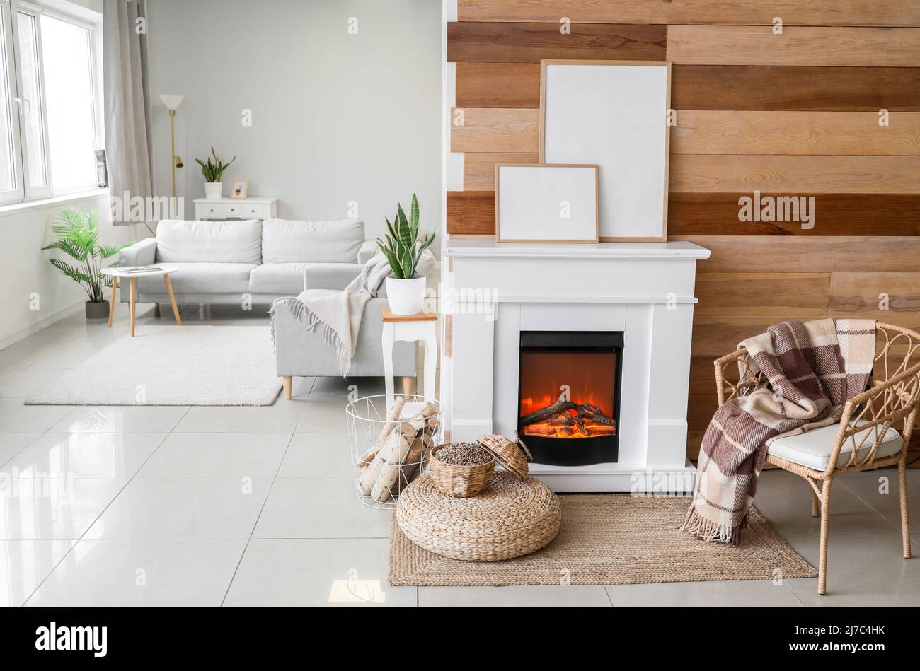 Interior of modern living room with mantelpiece, firewood and frames ...