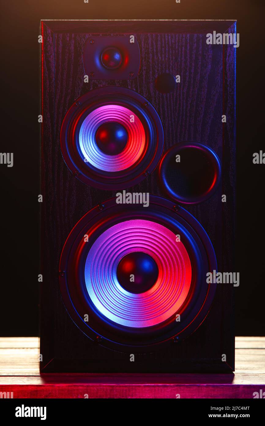 Modern loudspeaker on table against black background Stock Photo - Alamy