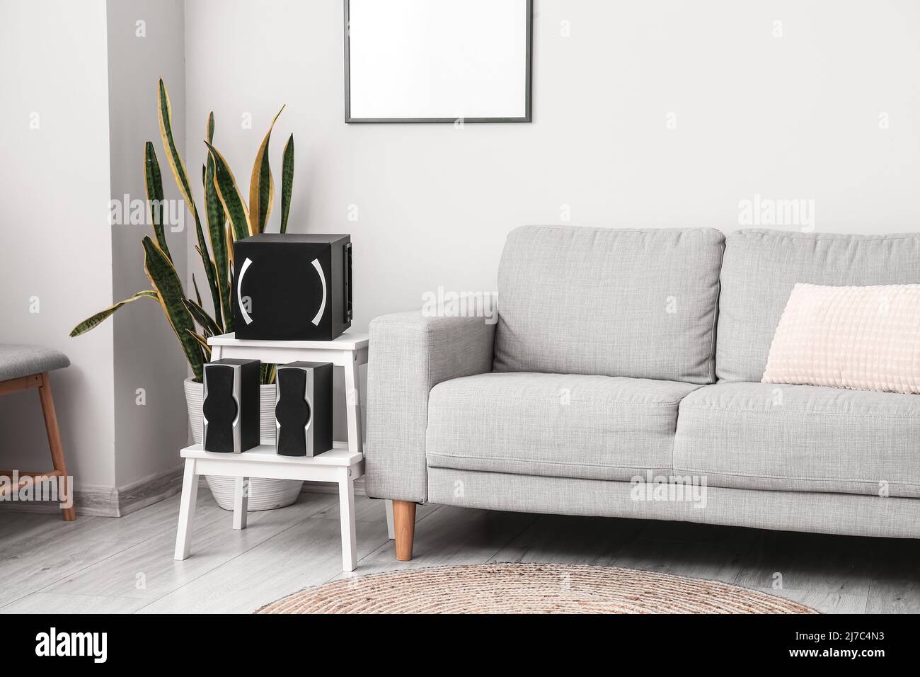 Loudspeakers on stepladder stool near sofa in living room interior ...