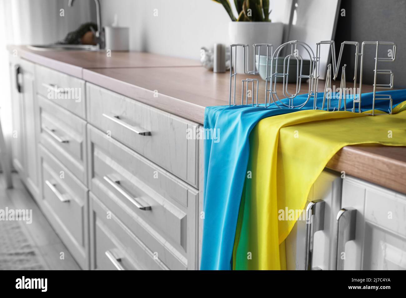 Decor in shape of word HOME with Ukrainian flag on counter in kitchen ...