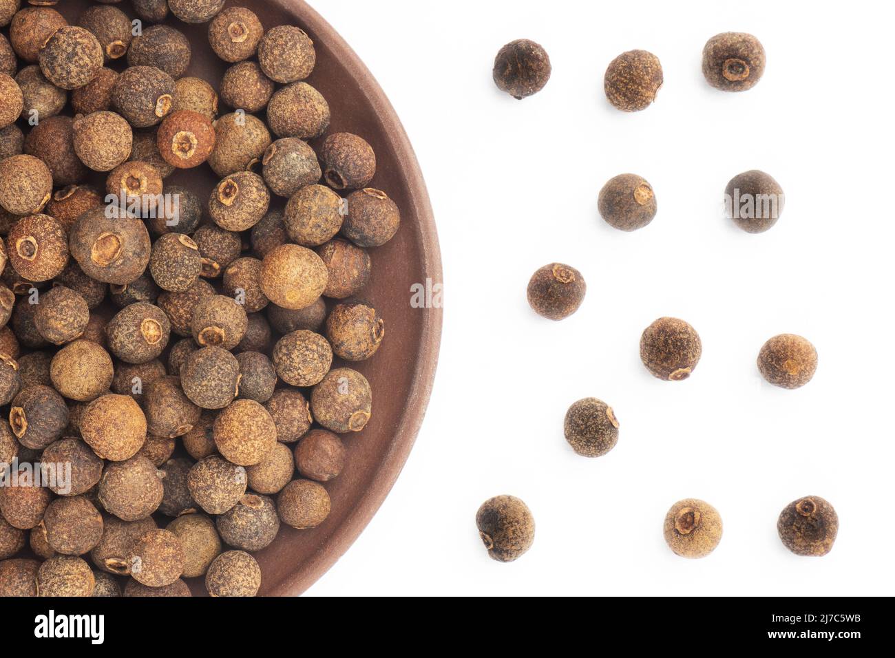 Spice Allspice in clay plate and bunch on white background. Flat lay ...
