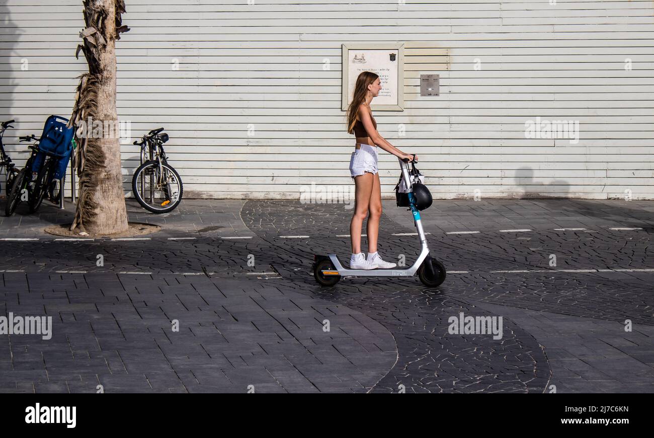 Tel Aviv, Israel - May 07, 2022 People rolling with an electric scooter ...
