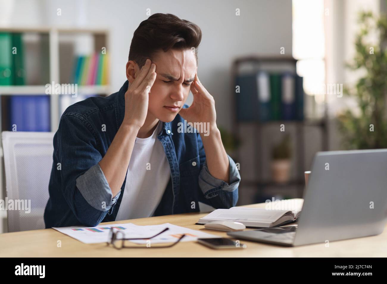Stressed Young Male Entrepreneur Suffering Headache While Sitting At ...