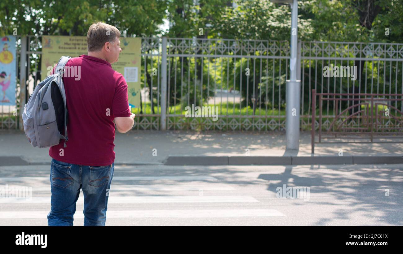 An adult man carefully crosses a dangerous pedestrian crossing Stock ...