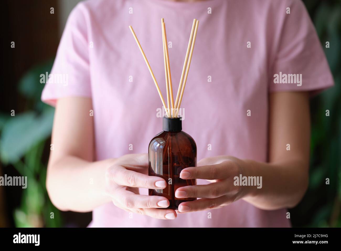 Woman holds jar with an aromatic diffuser of homemade fragrance in ...