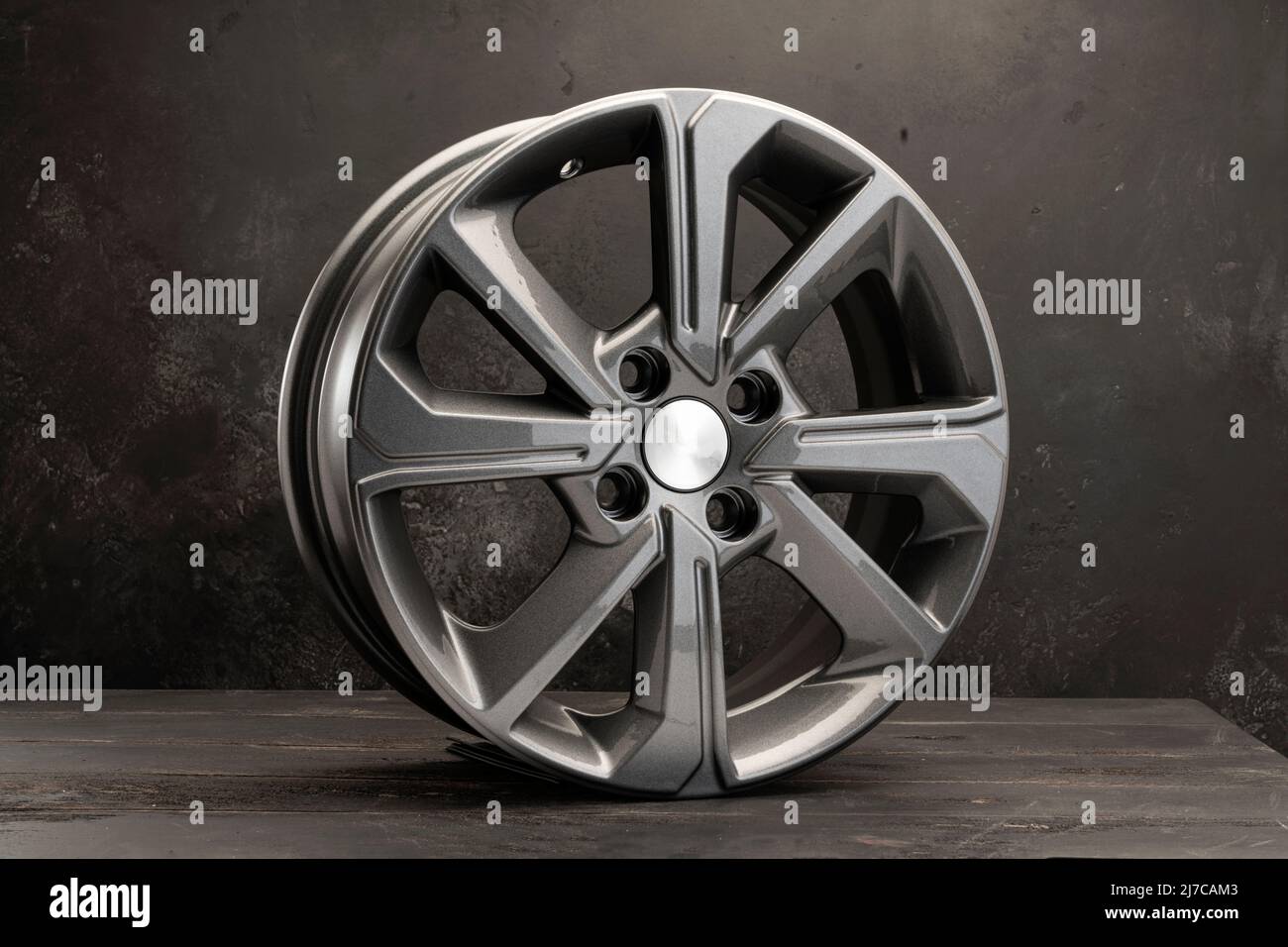 new grey alloy wheels on a dark textured black background. a wheel for ...