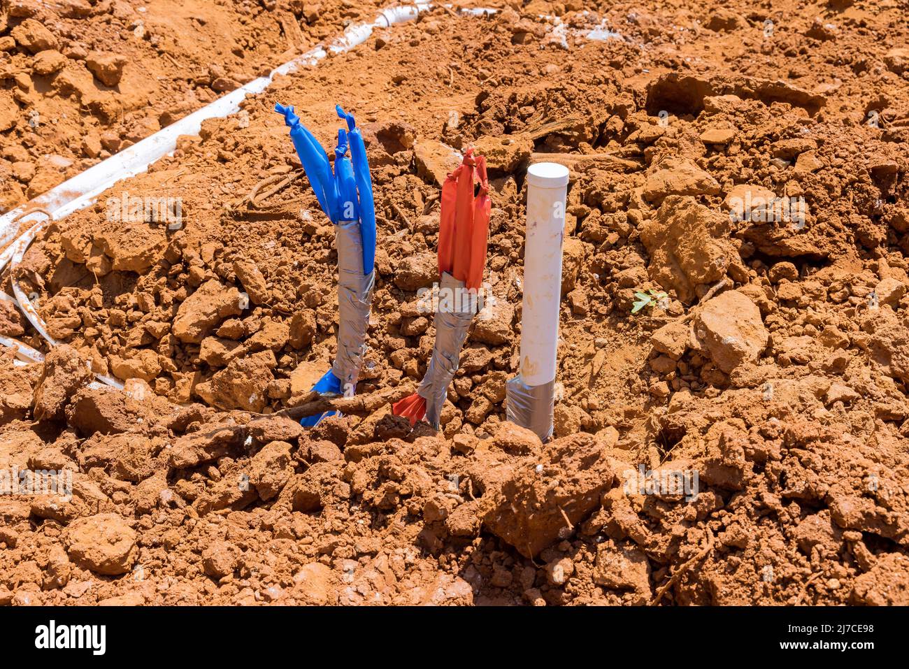 Laying water PVC plastic pipes in ground during plumbing construction ...