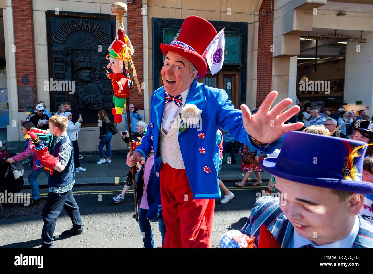 London, UK. 8 May 2022. A stilt-walker and puppeteers during a parade ...