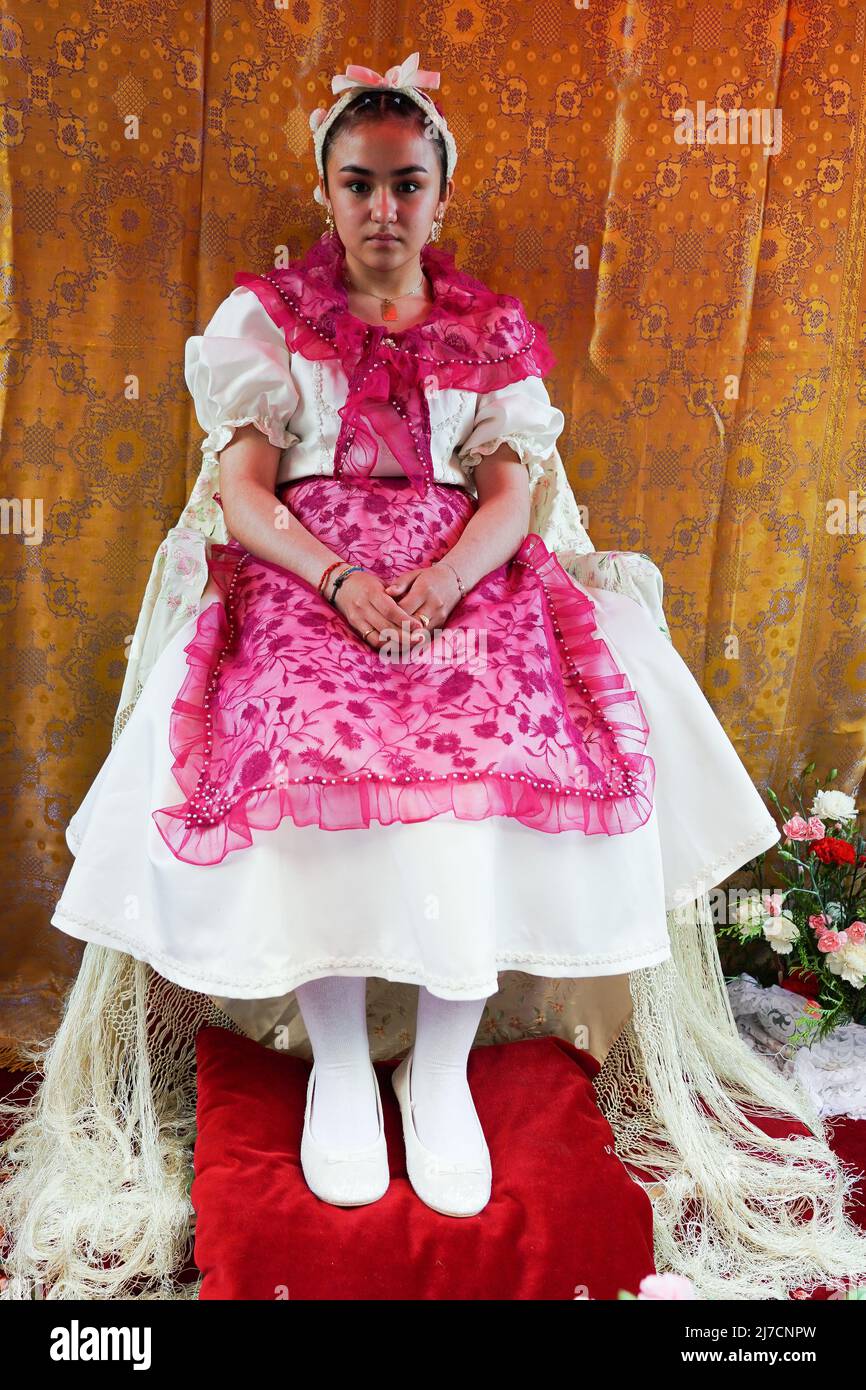 A girl, La Maya, sits on an altar during the celebration of La Maya ...