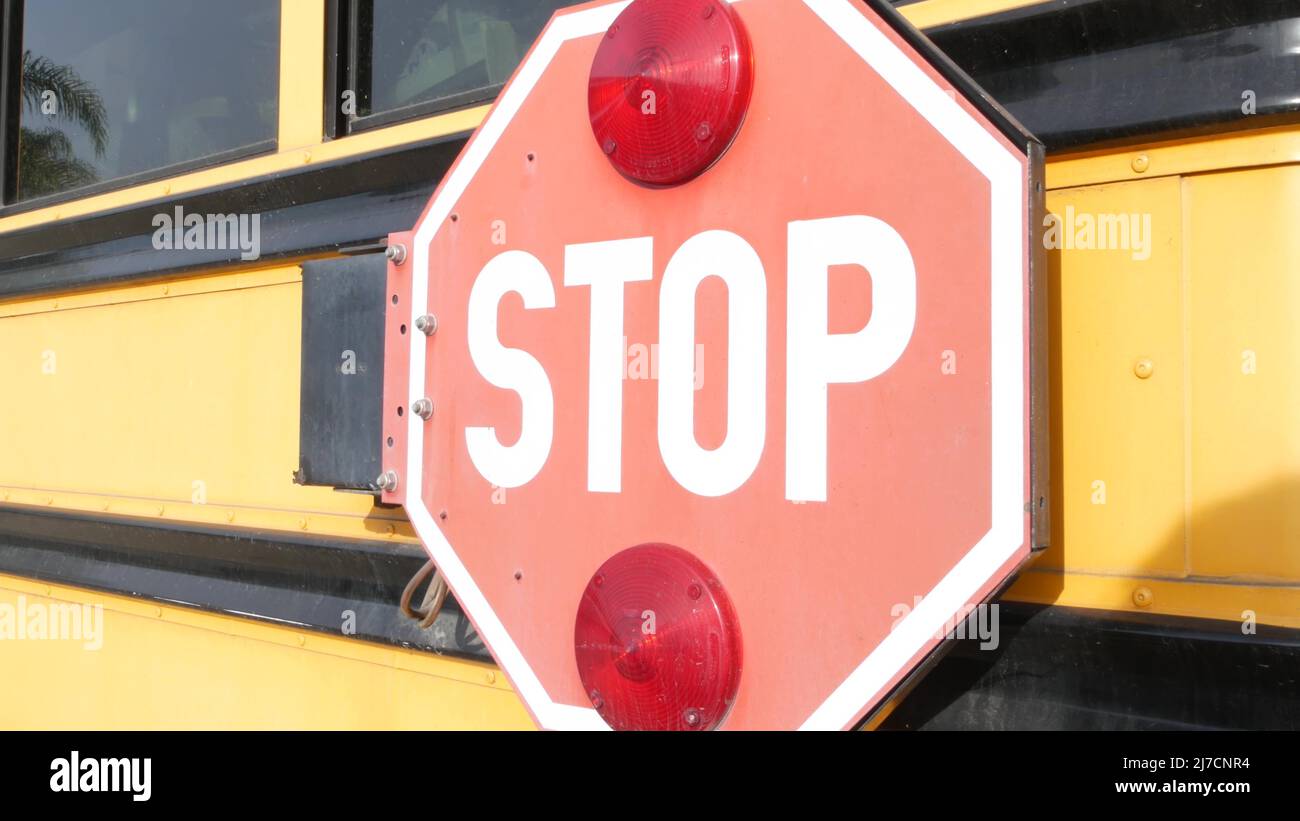 Red stop sign, yellow school bus in California, USA. Traffic warning on ...