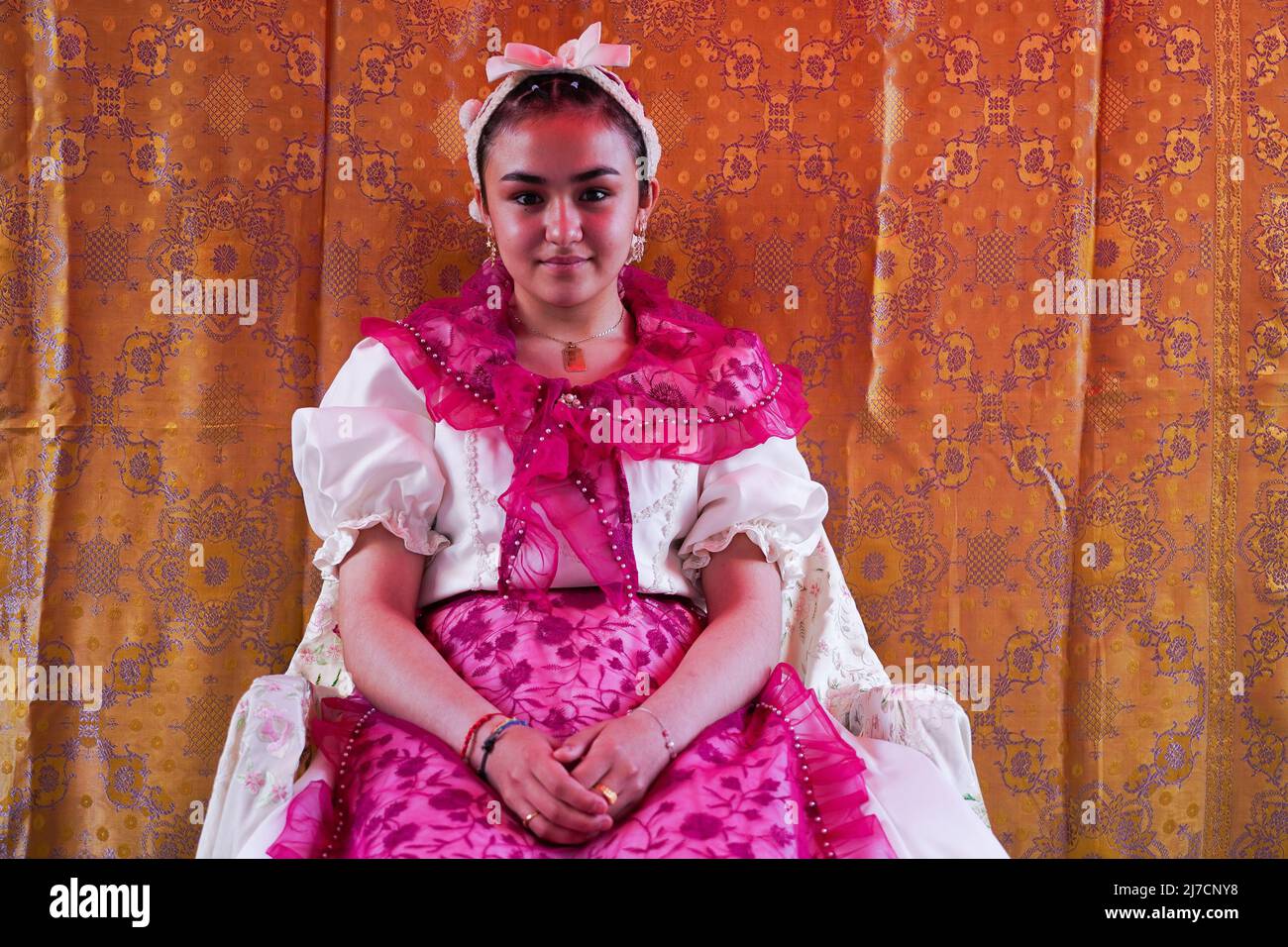 A girl, La Maya, sits on an altar during the celebration of La Maya ...
