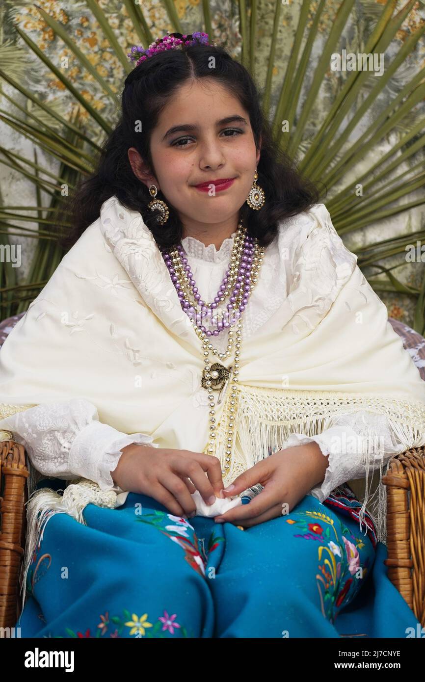 A girl, La Maya, sits on an altar during the celebration of La Maya ...