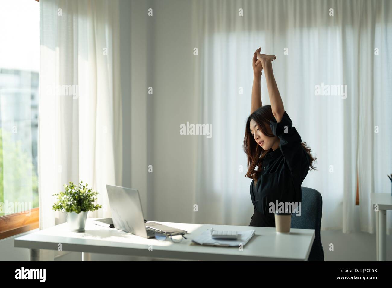 Satisfied asian woman relaxing with hands behind her head. Happy ...