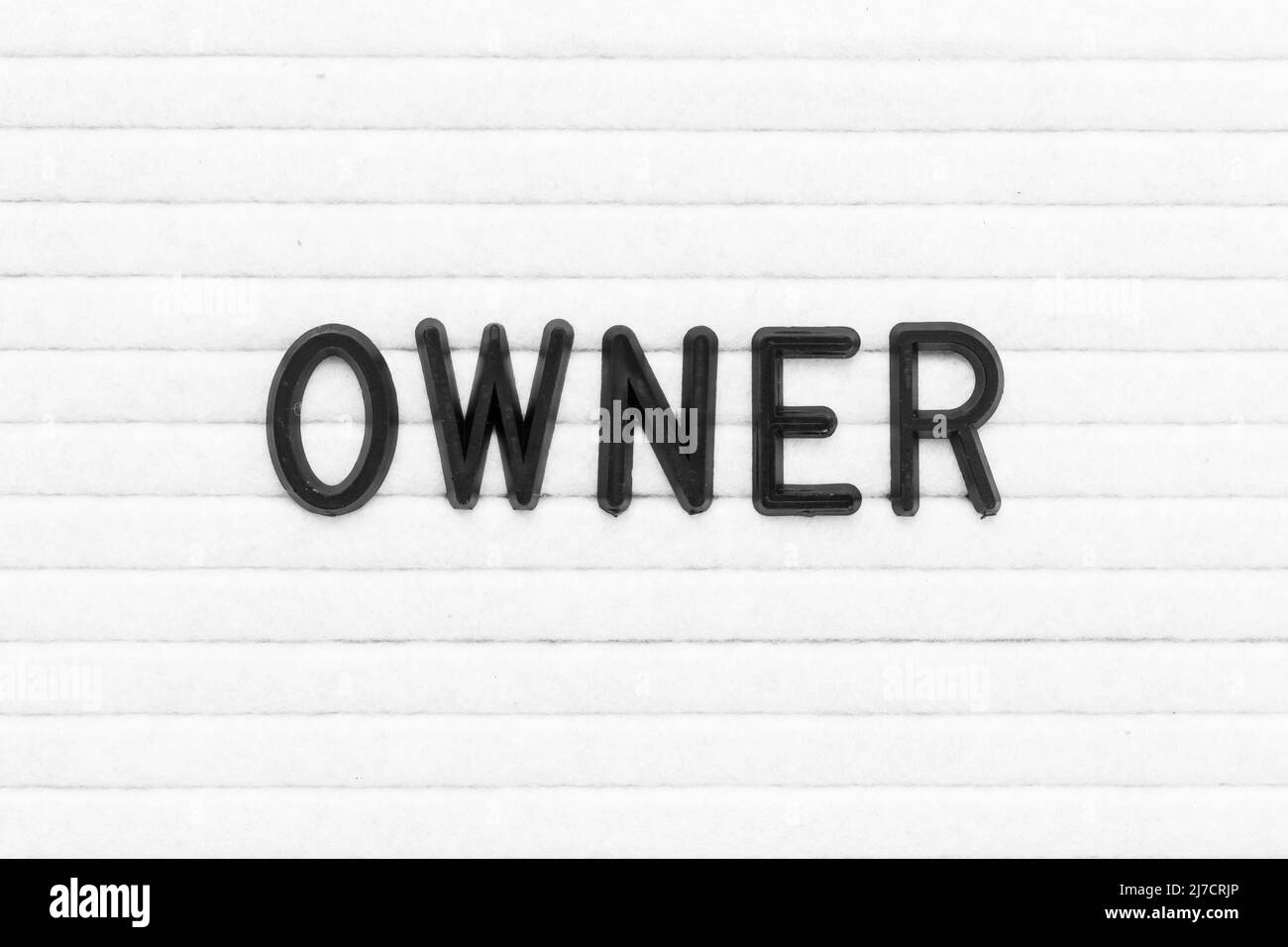 Black color letter in word owner on white felt board background Stock ...