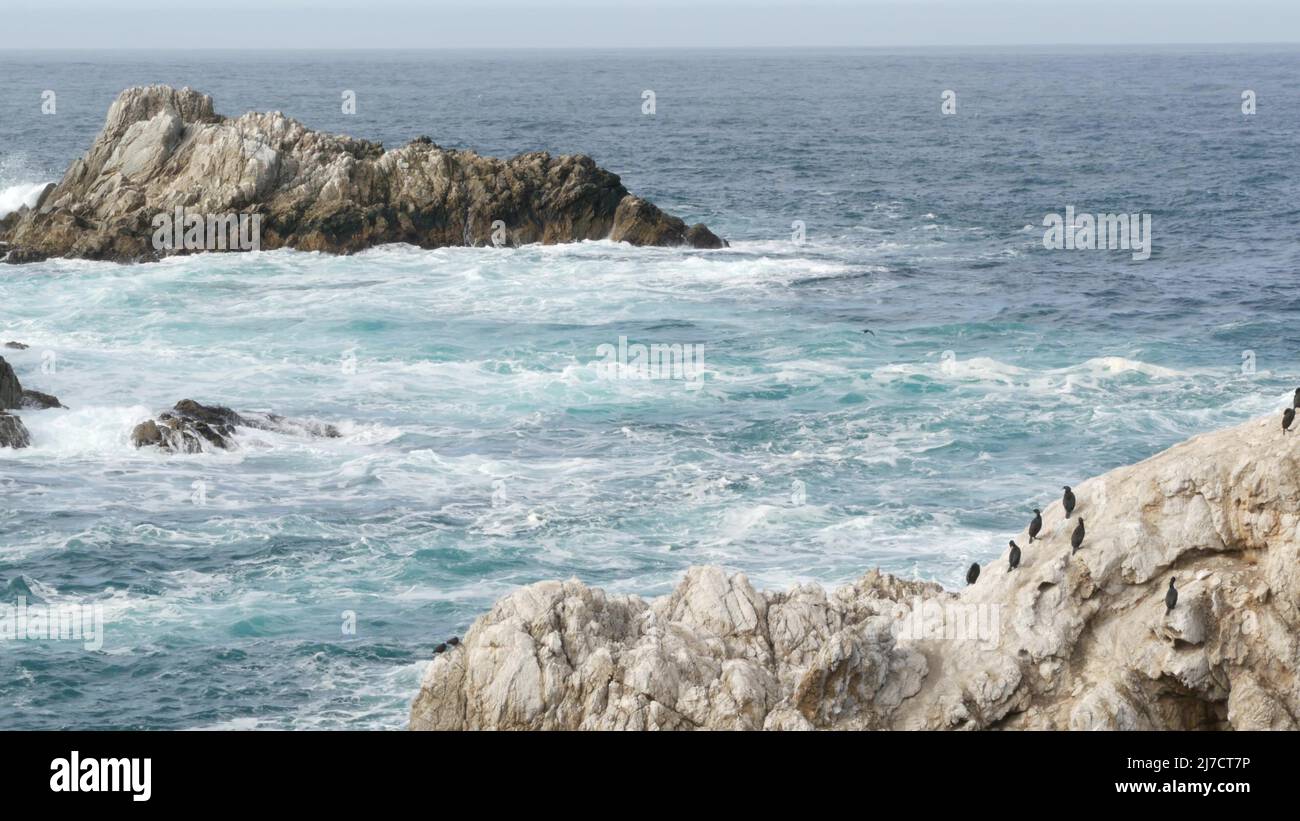 Rocky craggy dramatic ocean beach near Big Sur, 17-mile drive. Big blue ...