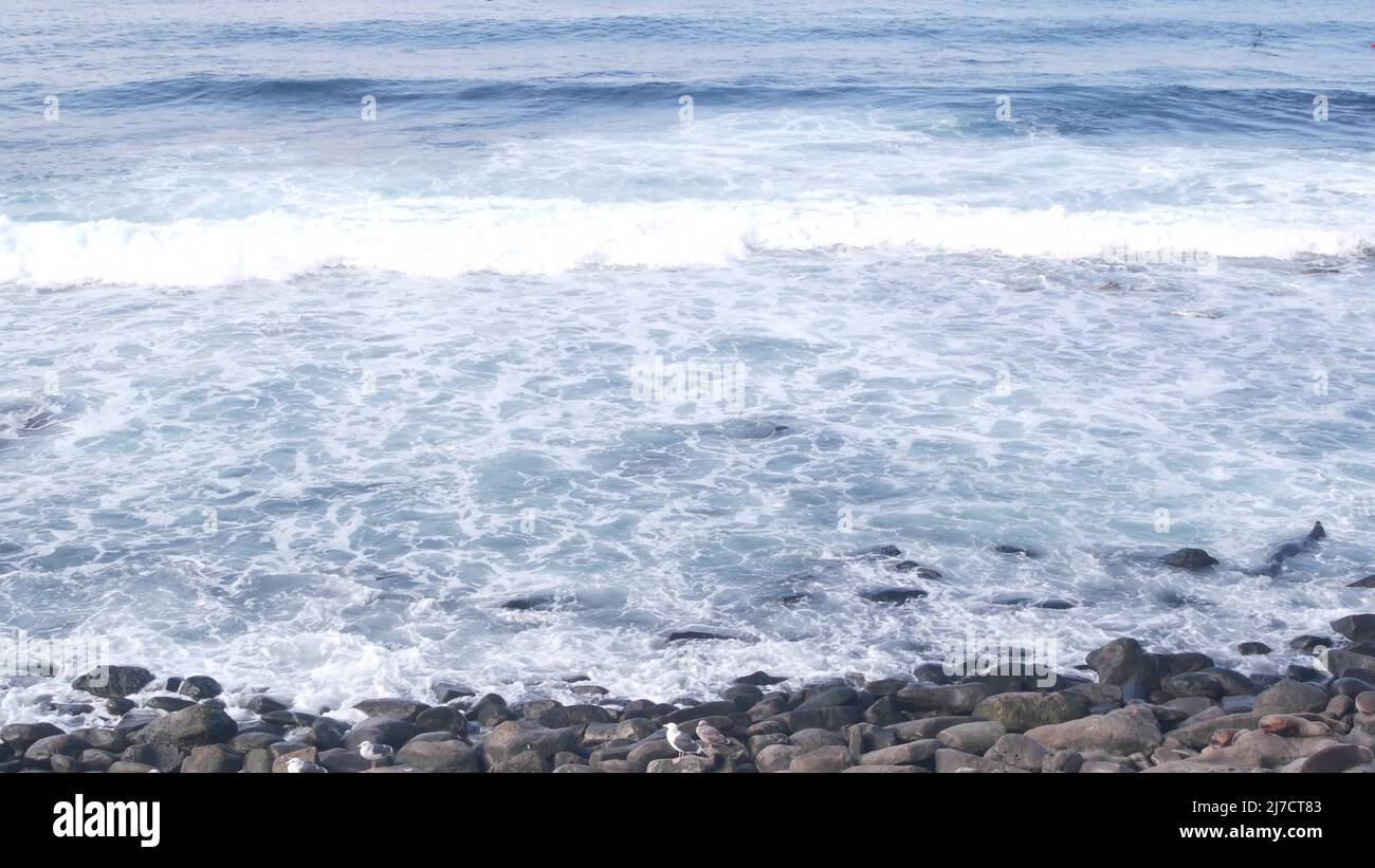 Ocean waves crashing on beach, sea water surface from above, cliff or ...