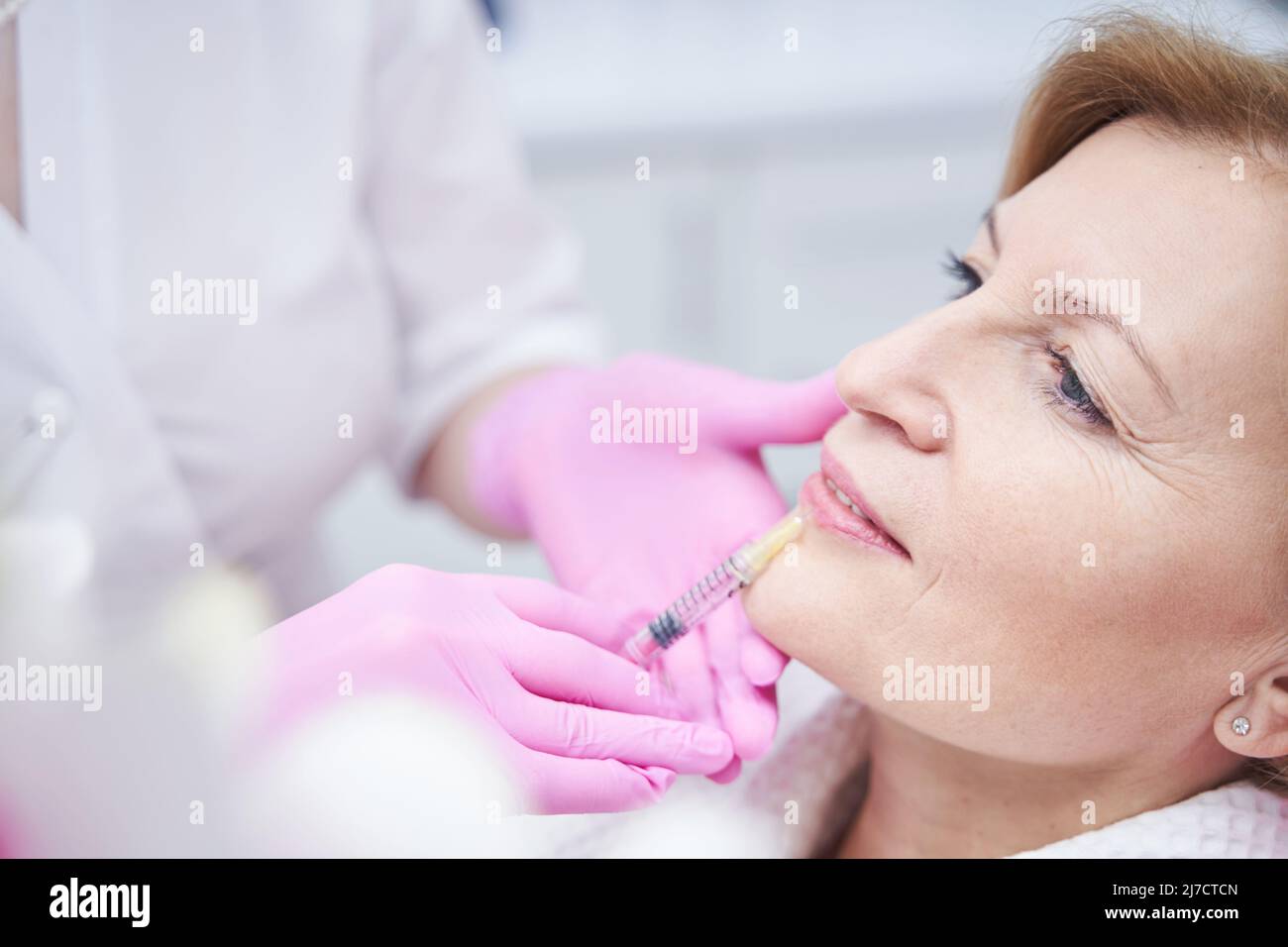 Adult woman receiving lip injection in beauty salon Stock Photo - Alamy