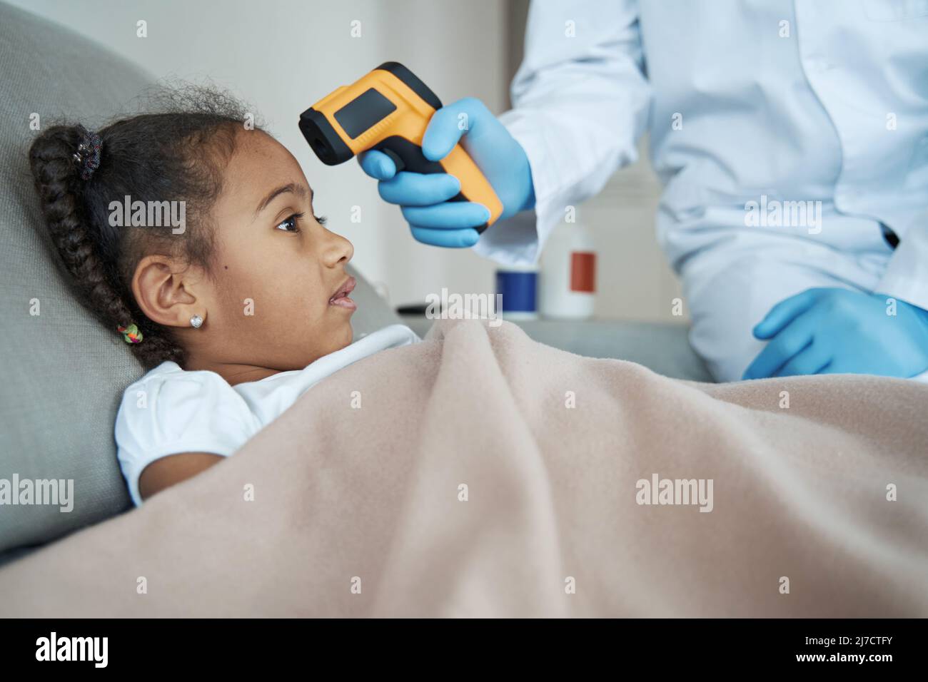 Girl is having her temperature taken with a non-contact thermometer ...