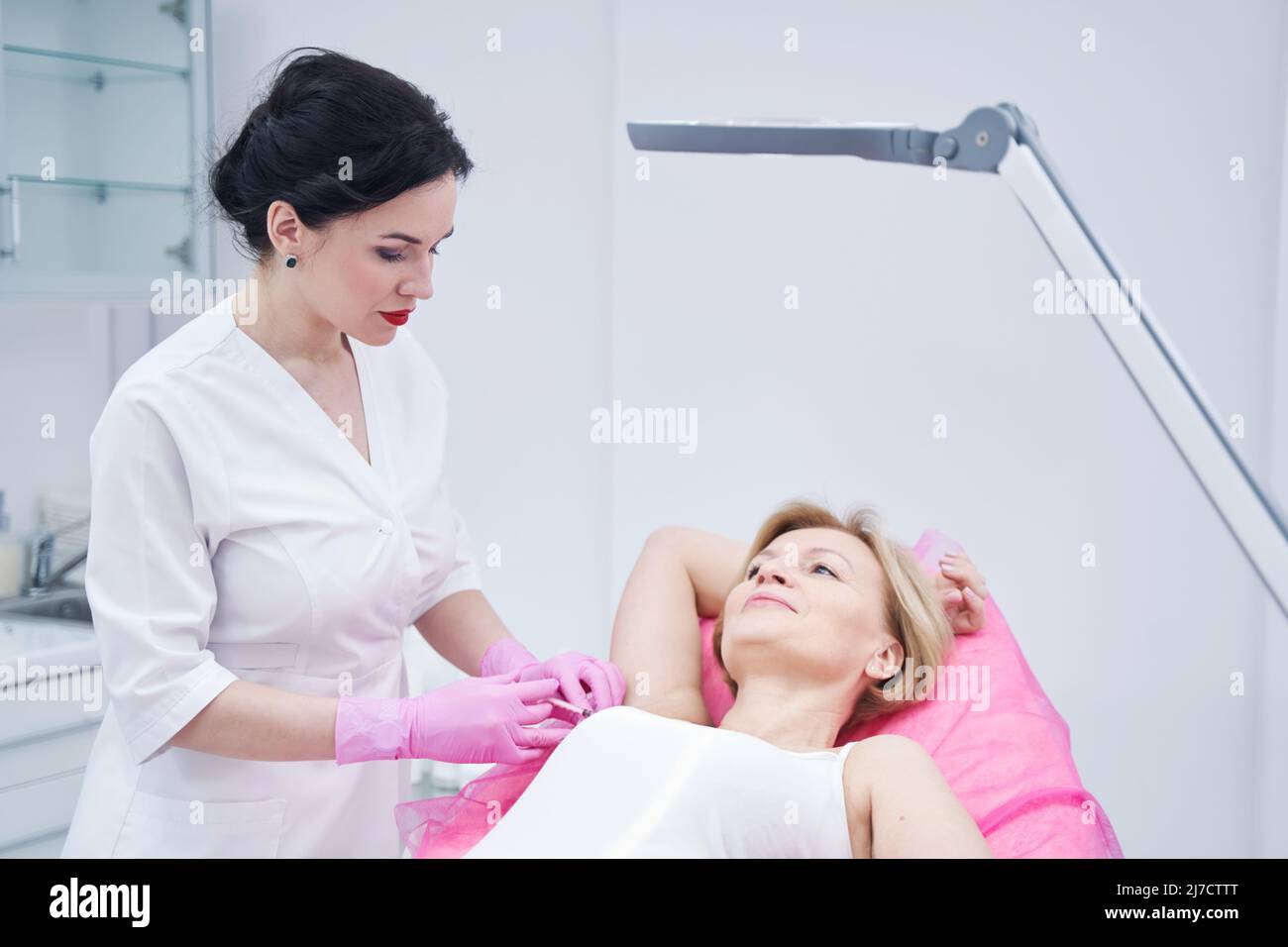 Woman receiving underarm injection in cosmetology clinic Stock Photo ...