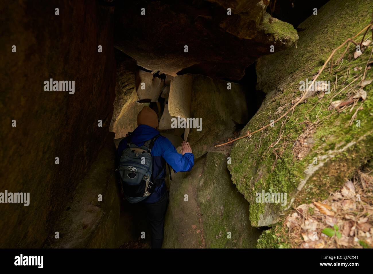 Person going inside cave within rocks in forest Stock Photo - Alamy