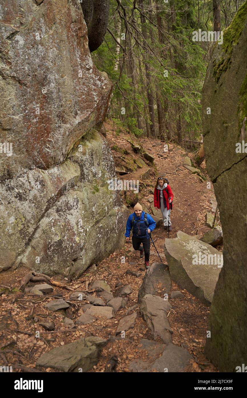Two hikers moving through passage between two mountains Stock Photo - Alamy
