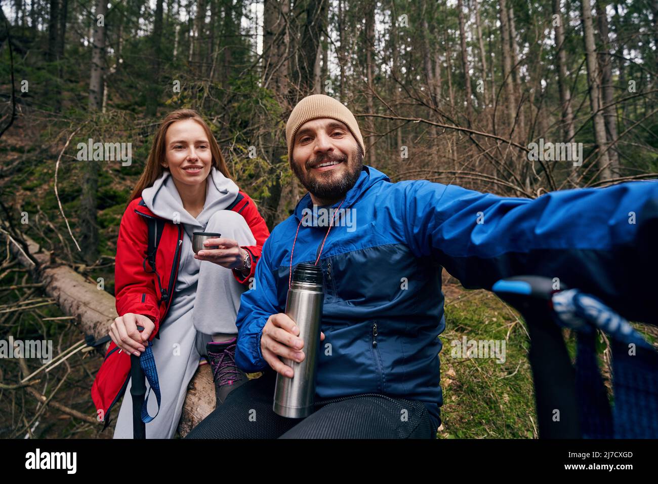 Male and female on fallen tree in forest taking selfie Stock Photo - Alamy