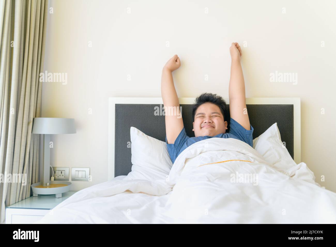 obese fat boy wakes up and stretching on bed in morning, Health care ...